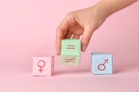 Female Hand Paper Cubes With Symbols Of Woman Man And Equal Mark On Color Background Concept