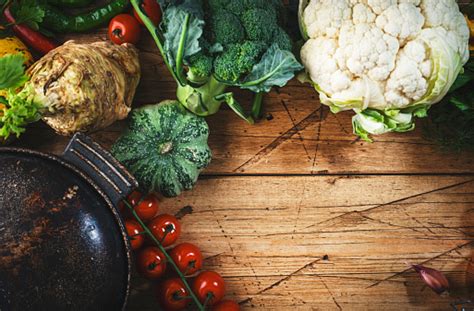 유기농 농장 채소가있는 가을 음식 배경 콜리 플라워 브로콜리 뿌리 셀러리 호박 허브 및 향신료 무쇠 팬이있는 소박한 나무 주방 테이블에 향신료 향신료 그라인더 커팅 보드 0