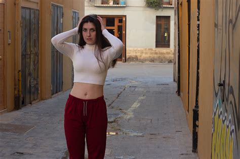 매력적인 백인 젊은 여성의 초상화는 머리에 손을 유지 찡그린 문제가 나쁜 분위기에있는 끔찍한 두통이 도시에서 흰색 상단과 빨간 바지 어두운 공기 텍스트 에 대한 장소 I