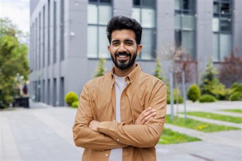 Portrait Of Young Hindu Programmer Man Outside Office Building With Crossed Arms Smiling And