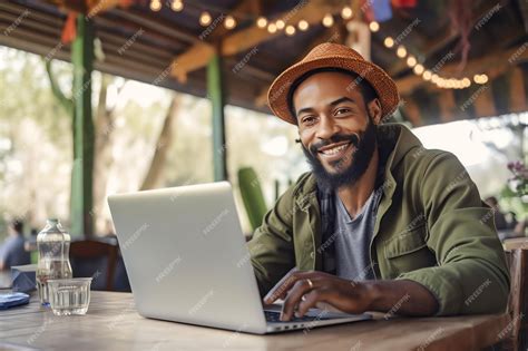 Premium Photo A Man Sits At A Table With A Laptop In Front Of Him