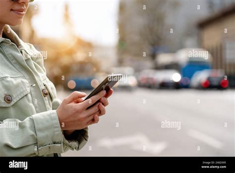 Urban Woman Using Her Mobile Phone While Stands Next To City Road