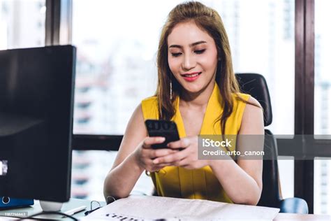 노트북 컴퓨터와 함께 앉아서 작업하고 스마트 폰창조적 인 비즈니스 사람들이 현대 작업 로프트에서 그녀의 워크 스테이션에서 계획