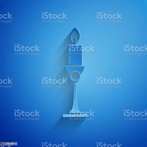 종이 컷 파란색 배경에 고립 된 촛대 아이콘에 불타는 촛불 구식 조명 촛불 불타는 불꽃이 있는 원통형 촛불 스틱 종이 아트 스타일입니다 벡터 일러스트레이션 교회에 대한 스톡