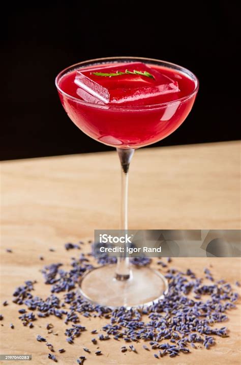 커다란 얼음 조각이 있는 쿠페 잔에 담긴 빨간 칵테일이 꽃으로 장식된 테이블 위에 서 있습니다 0명에 대한 스톡 사진 및 기타 이미지 Istock