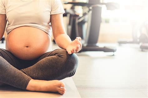 요가룸의 피트니스 센터에서 활동적인 임산부 운동을 합니다 임신 한 배에 아기를 들고 젊은 기대 어머니 출산 전 관리 및 여성 임신 개념 건강한 생활방식에 대한 스톡 사진 및