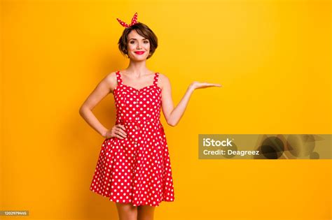 초상화 의 긍정적 인 쾌활한 소녀 프로모터 손 선물 광고 프로모션 추천 추천 추천 착용 좋은 모습 빈티지 밝은 옷 노란색 색상 배경 위에 고립 갈색 머리에 대한 스톡 사진