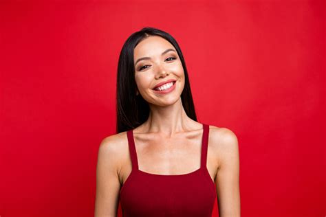 붉은 빛 배경에 고립 된 그녀의 백색 빛나는 미소로 귀여운 달콤한 화려한 좋은 멋진 사랑 스러운 멋진 숙 녀 그녀가 카메라를 봐의 틸트 머리 옆으로 아시아인에 대한 스톡