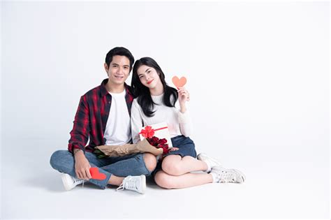 집에서 아름 다운 젊은 부부 포옹 키스와 함께 시간을 보내는 동안 함께 세인트 발렌타인 데이를 축 하 하는 동안 손에 선물 상자와 공기 풍선 배경에 마음의 모양 가리기에