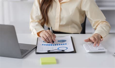 사무실 책상 세금 보고서 회계 통계 및 분석 연구 개념에서 수학 금융을 수행하기 위해 계산기와 노트북을 사용하는 아시아 비즈니스