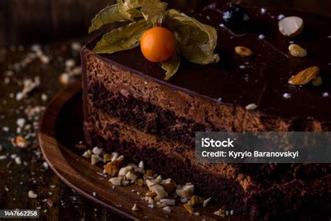 Physalis 너트 조각 나무 테이블에 건포도와 초콜릿 유약에 초콜릿 케이크 조각 수평 방향 0명에 대한 스톡 사진 및 기타 이미지 Istock