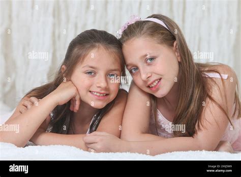 Portrait Of Two Pretty Cheerful Preteen Girls In Elegant Dresses On