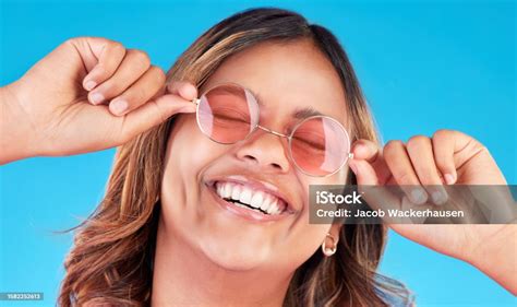 패션 선글라스 얼굴 그리고 푸른 배경에 고립된 스튜디오의 행복한 여자 미소 안경 스타일 캐주얼한 색조 미학에 대한 긍정적인 마인드 Z세대 눈을 감은 인도 모델 20 24세에