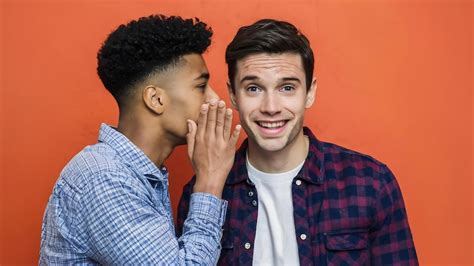 Premium Photo Young Man Whispering A Secret In His Friends Ear
