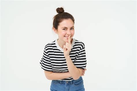 Una Hermosa Chica Coqueta Sostiene El Dedo En Los Labios Prometiendo Mantener El Secreto Foto
