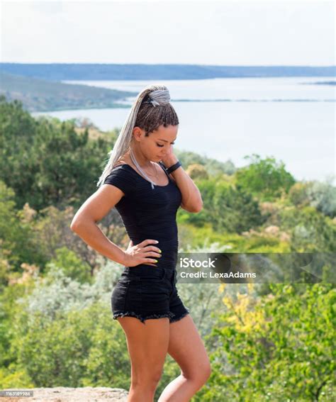 검은 옷을 입은 아프로 브레이드를 입은 아름다운 검게 그을린 백인 여성이 호수 근처 절벽에 서 있습니다 땋은 머리에 대한 스톡 사진 및 기타 이미지 Istock