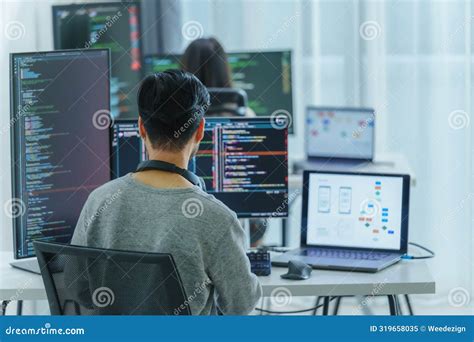 Asian Software Developers Working On Multiple Screens Displaying Code