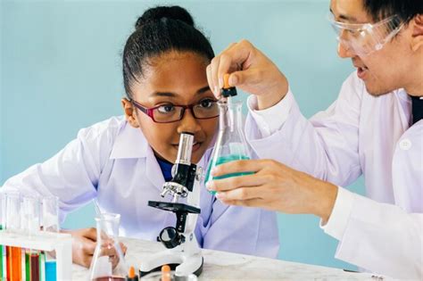 Premium Photo Girl By Man And Equipment On Table In Laboratory