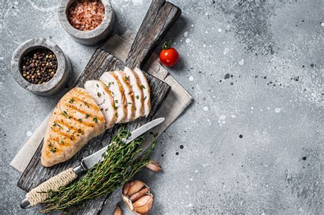 도마에 얇게 썬 터키 구운 유방 필레 스테이크 회색 배경 맨 위 보기입니다 복사 공간 칠면조 흰 살코기에 대한 스톡 사진 및