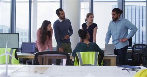 Diverse Architectural Team Collaborating On Project In Modern Office