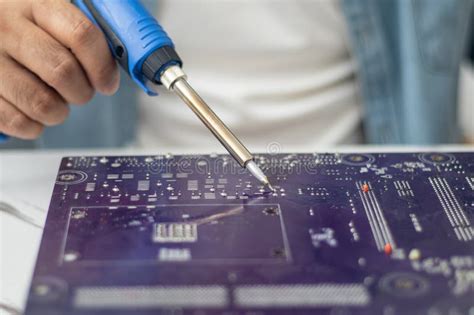 Technician Using A Soldering Iron To Repair A Circuit Board Stock Image