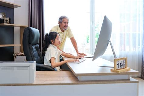 Young Asian Schoolgirl Is Doing Her Class Homework Assignment At Home With Advice From