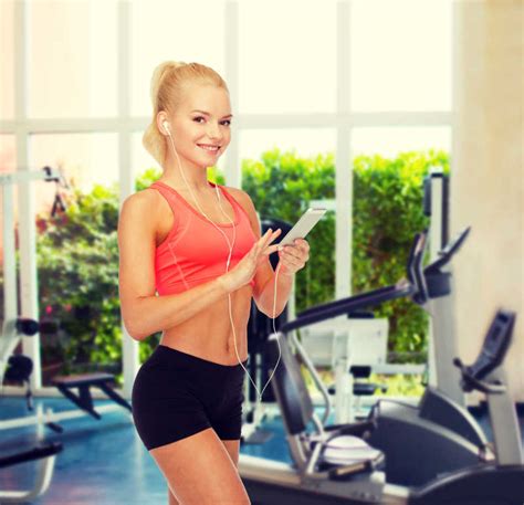 健身房里戴着耳机的年轻女孩图片 在健身房戴着耳机的年轻女孩素材 高清图片 摄影照片 寻图免费打包下载