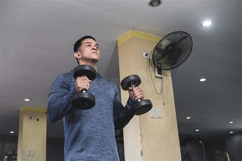 A Fit Man In A Sweatshirt Does Standing Dumbbell Hammer Bicep Curls Strict Isolation Exercise