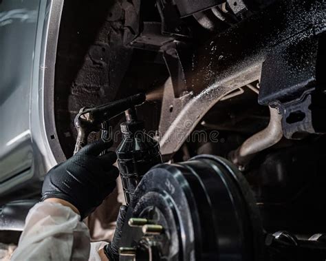 The Master Sprays An Anti Corrosion Compound On The Bottom Of The Car Stock Photo Image Of