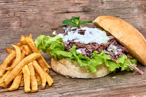 Tzatziki 소스 Bbq 소스 및 나무 배경 튀김 그린 샐러드와 바베 큐 뽑아 돼지고기 샌드위치 갈기갈기 찢어진에 대한 스톡