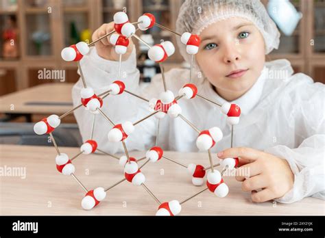 A Babegirl In A White Coat Demonstrates An Atomic Model Of A Molecule Using A Set Of Three
