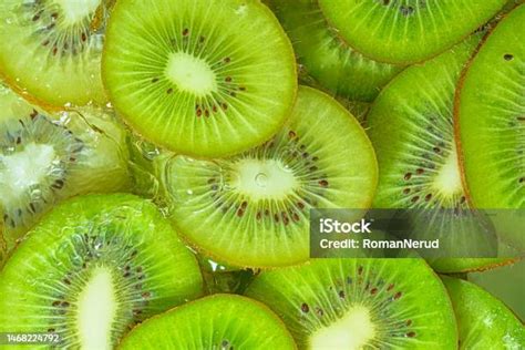 흰색 바탕에 물에 키위 과일 조각 키위 과일은 거품이있는 액체로 클로즈업됩니다 물에 녹색 익은 키위 과일 조각 물에 과일의 매크로 이미지입니다 수평 이미지 평면도 평면