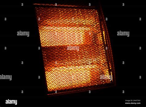 Glowing Heating Element Of Hot Home Electric Heater Orange Warm Light On Black Background Stock