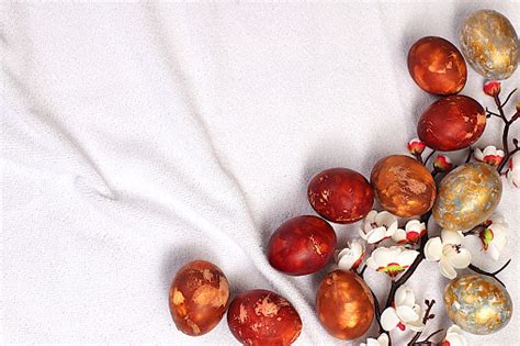 양파 껍질과 히비스커스 차로 그린 대리석 부활절 달걀 가벼운 수건에 벚꽃 가지 부활절 축하 개념 가정 요리에 대한 부활절 요리