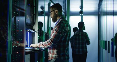Server Room With A Robot Being Set By An Engineer With A Computer Stock