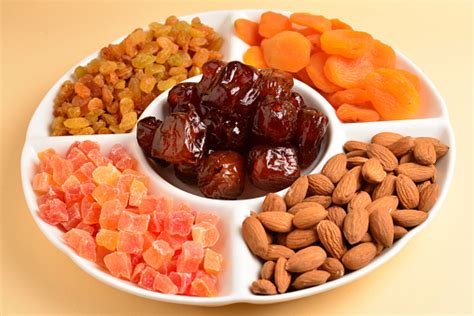 흰 접시에 말린 과일과 견과류를 섞어 줍니다 살구 아몬드 건포도 대추 열매 베이지색 배경에 텍스트 또는 디자인을 위한 공간입니다 0명에 대한 스톡 사진 및 기타 이미지