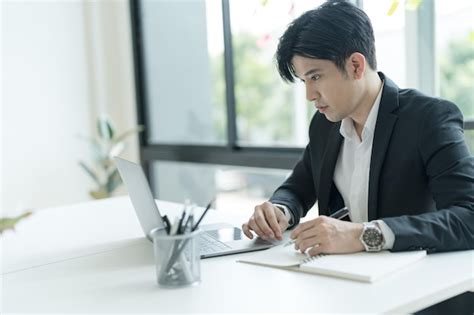 Premium Photo Young Businessman Opening A Notebook View Emails From Customers Sent And Write