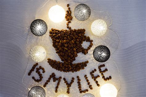 접시를 가진 커피 한 잔모양의 그림은 커피 콩으로 만들어졌으며 그 아래에는 비문 커피가 내 인생입니다 빛나는 공은 주변에