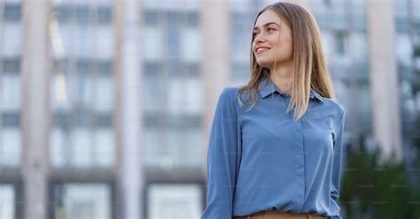 건물 배경 위에 파란색 부드러운 셔츠를 입고 초상화를 웃고 있는 금발의 젊은 여자 사진 Unsplash의 컴퓨터 이미지