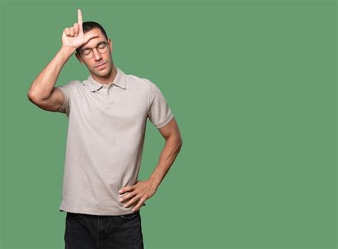 Premium Photo Concentrated Young Man Making A Gesture Of Distrust