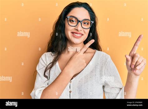 beautiful middle eastern woman wearing casual clothes and glasses smiling and looking at the