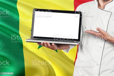 세네갈 국기 배경에 빈 화면으로 노트북을 들고 Senegalese 요리사 복사 공간에 대 한 유니폼과 포인팅 노트북을 입고 요리 고급 요리에 대한 스톡 사진 및 기타 이미지