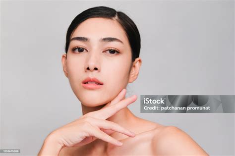 깨끗하고 신선하고 밝은 피부 긍정적 인 감정으로 행복과 쾌활한 젊은 아름다운 아시아 여성의 면 회색 배경에 고립 된 뷰티 화장품 및 얼굴 치료 개념 건강관리와 의술에 대한