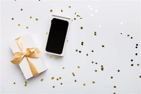 골드 리본과 스마트폰이 있는 기프트 박스를 컬러 배경 상단 보기로 오픈했습니다 빈 오픈 박스 포장 모형 디자인템플릿 브랜딩 모형
