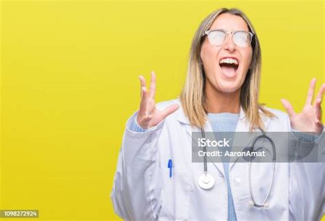 젊은 아름 다운 의사 여자 헤드폰 고립 된 배경 미친 고 미친 소리와 적극적인 식와 팔 제기 함 좌절 개념입니다 감정에 대한 스톡 사진 및 기타 이미지 Istock