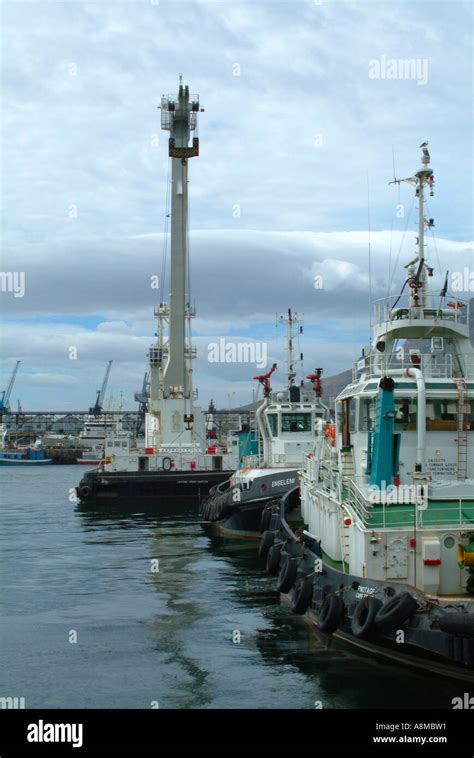 Large Powerful Ocean Going Tug Boat And Floating Crane In Harbour At