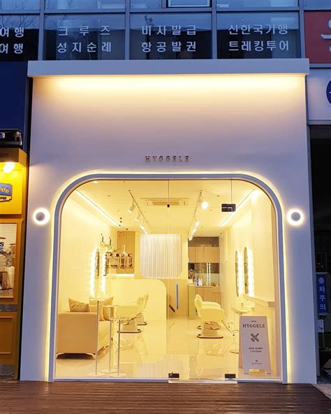 The Entrance To A Store With Lights On Its Windows And Furniture In Front