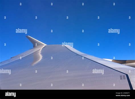 Wing And Curved Wing Tip Of A Modern Passenger Jet In Flight Against A Deep Blue Sky No People