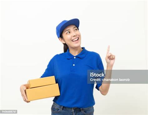 고립 된 흰색 배경에 소포 판지 상자를 들고 서있는 파란색 유니폼을 입은 행복한 배달 아시아 여성 웃는 여성 배달 상자 패키지 서비스 노동자를 보냅니다 나름에 대한 스톡