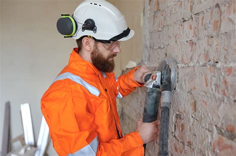 건축업자는 생산성을 높이기 위해 연삭기를 사용하여 벽돌 벽을 연삭합니다 건강관리와 의술에 대한 스톡 사진 및 기타 이미지 건강관리와 의술 건설 기계류 건설 산업